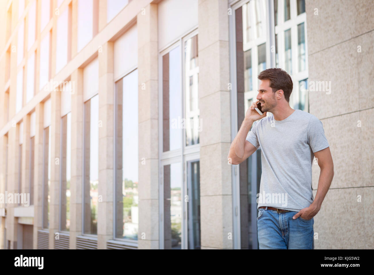Man walking in the city, making a phone call Stock Photo - Alamy