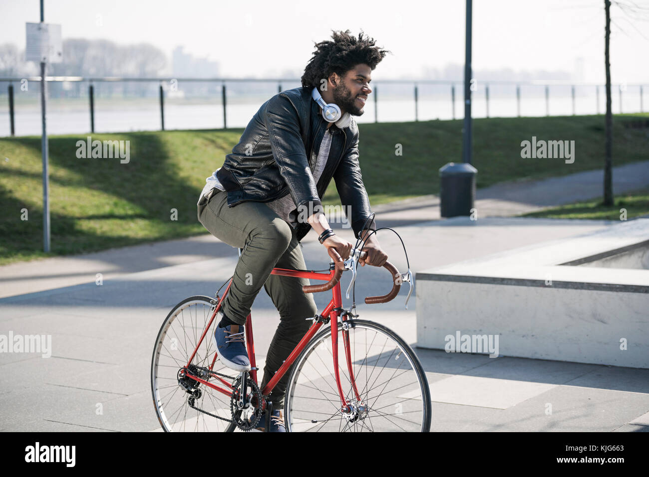 Smiling man riding bicycle at the riverside Stock Photo - Alamy
