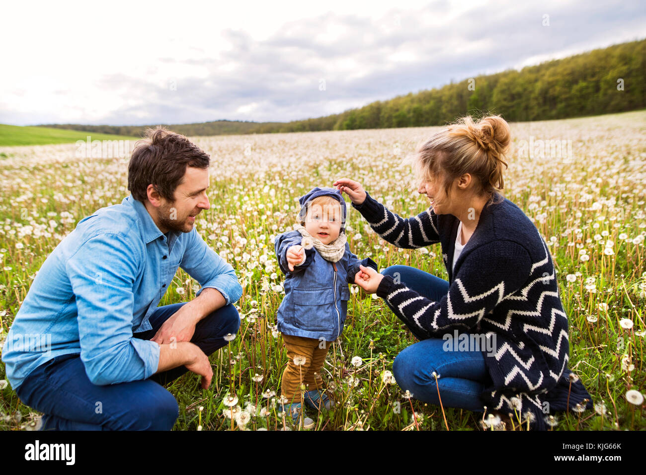 Cute little boy with parents in dandelion field Stock Photo - Alamy