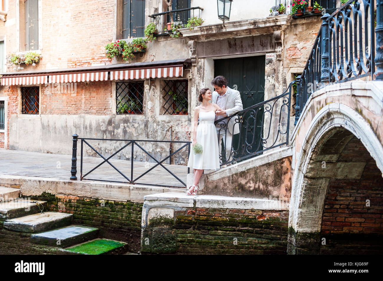 Italy, Venice, bridal couple standing face to face at canal Stock Photo ...