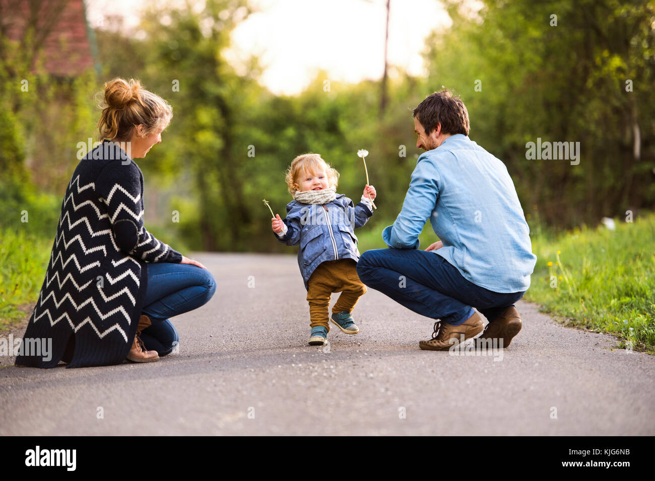 Cute little boy with parents on field path Stock Photo - Alamy