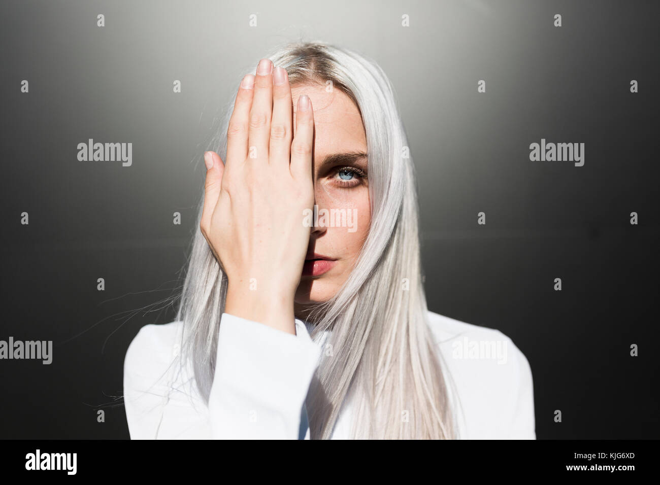Portrait of serious young woman covering one eye Stock Photo - Alamy