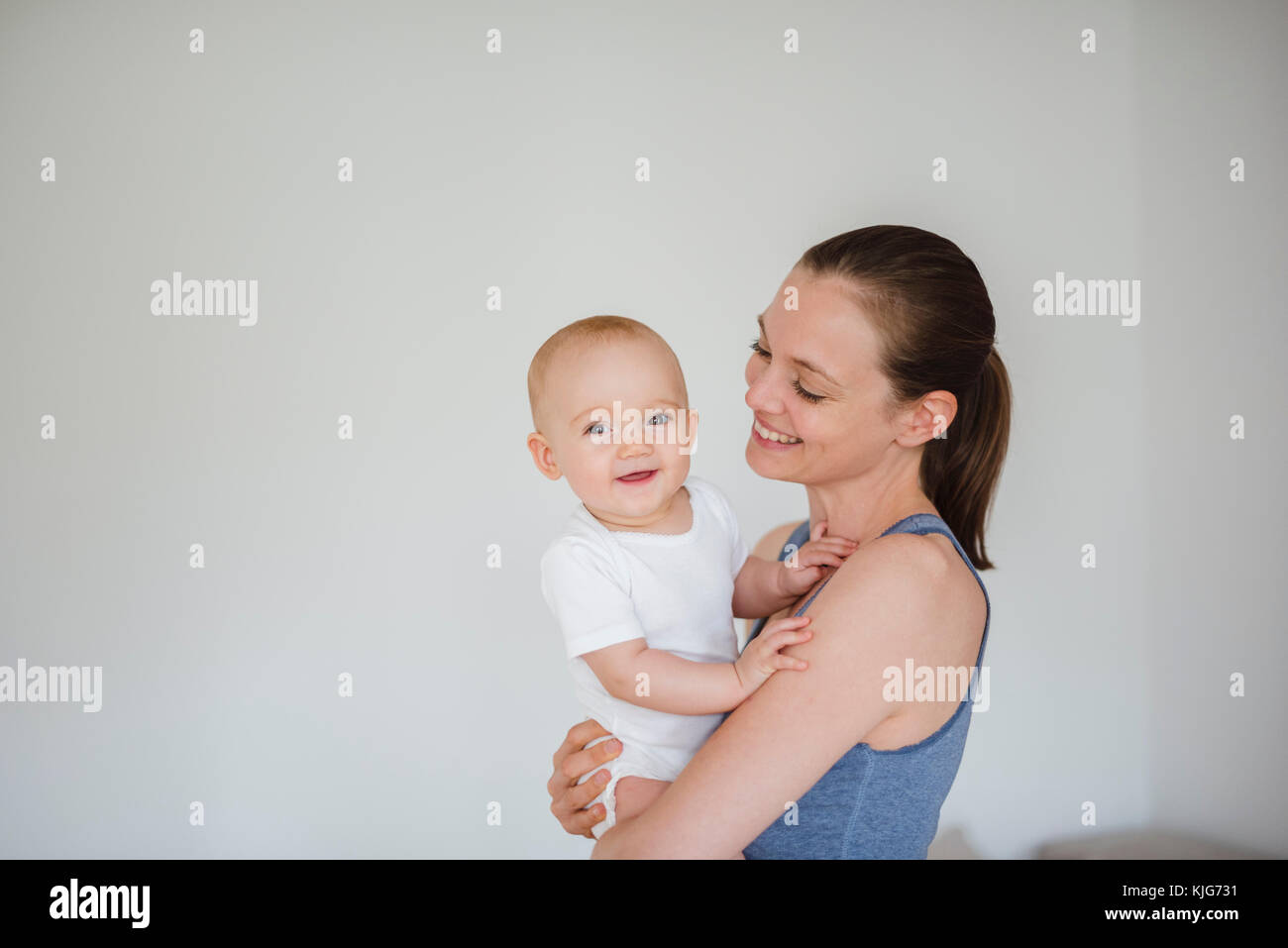Mother holding baby girl at home Stock Photo - Alamy