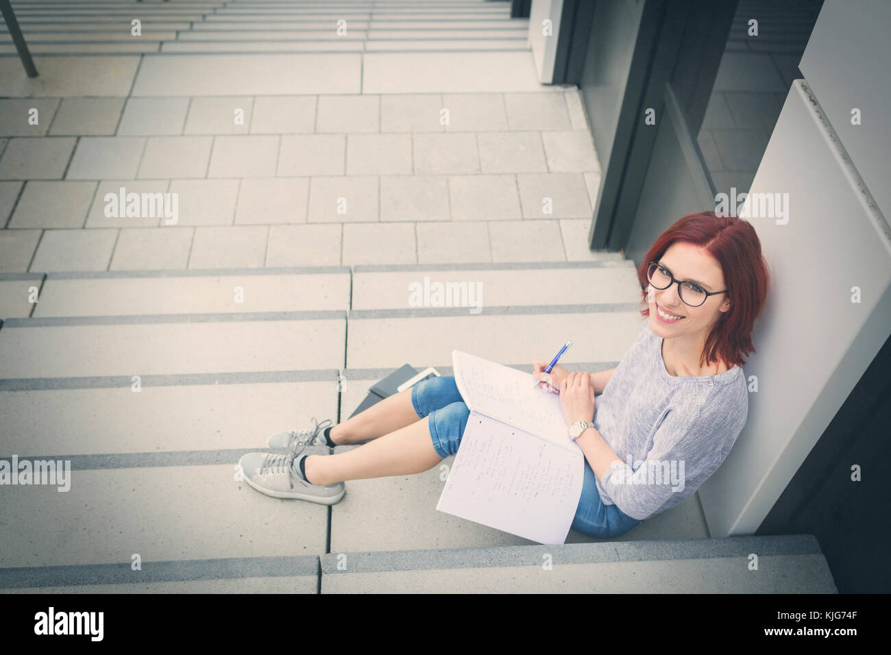 Young students writing notes into notebook Stock Photo - Alamy