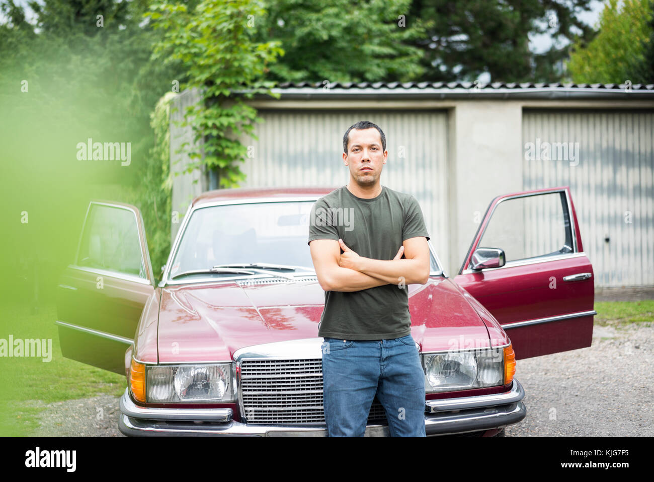 Portrait of serious man standing in front of car Stock Photo - Alamy
