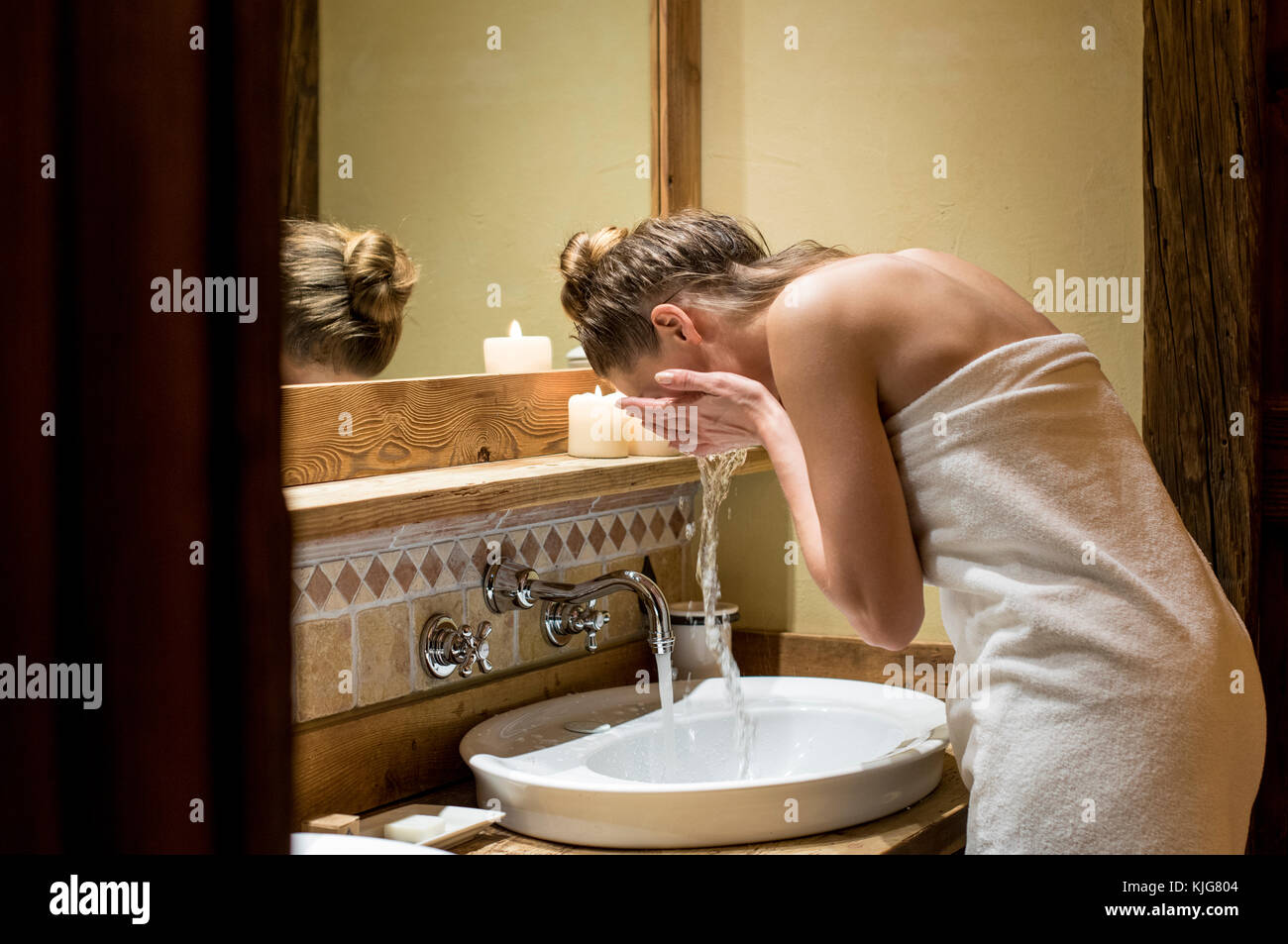 Woman washing her face in bathroom Stock Photo - Alamy