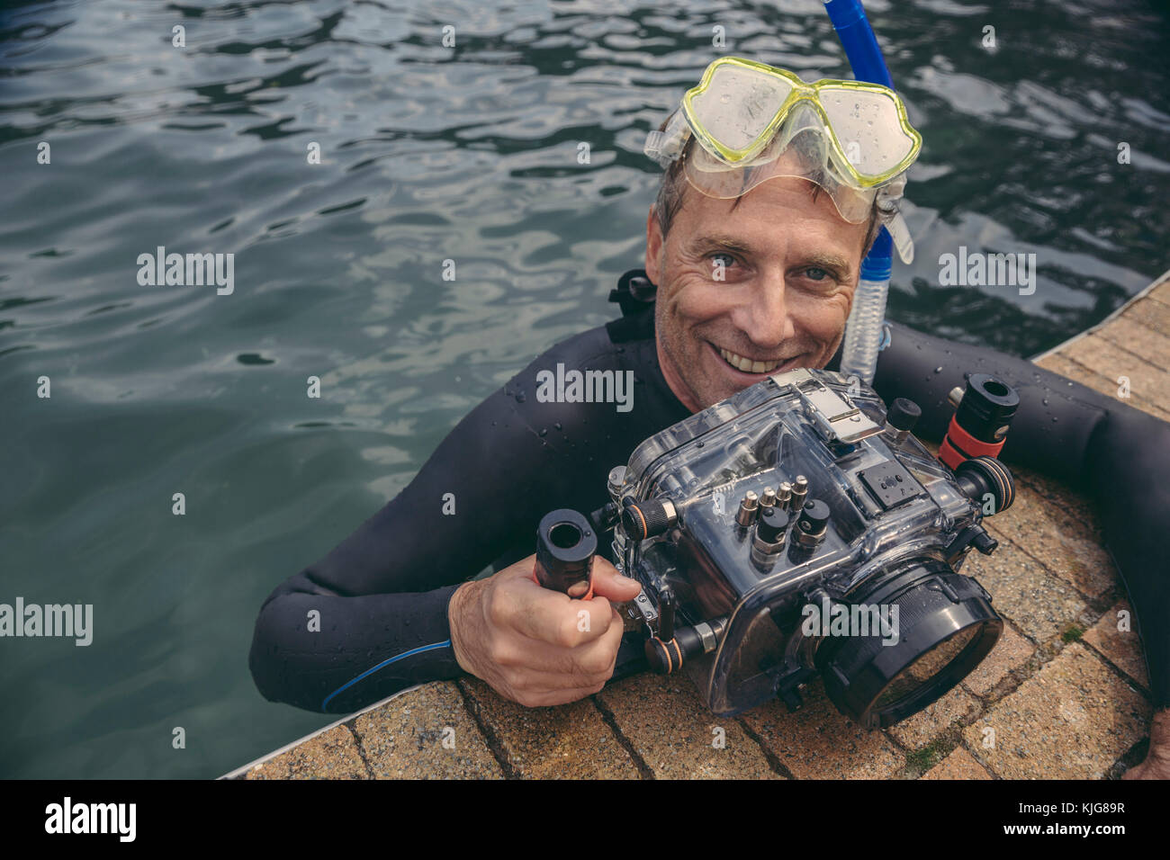 Portrait of happy man with underwater DSLR camera case in water Stock ...