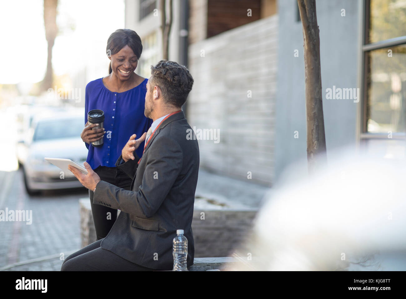 Colleagues talking outside office building Stock Photo - Alamy