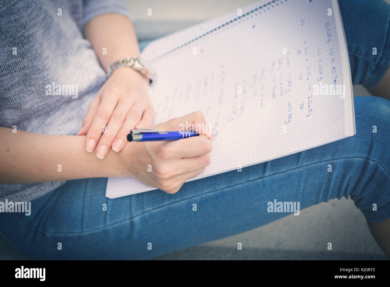 Young students writing notes into notebook Stock Photo - Alamy