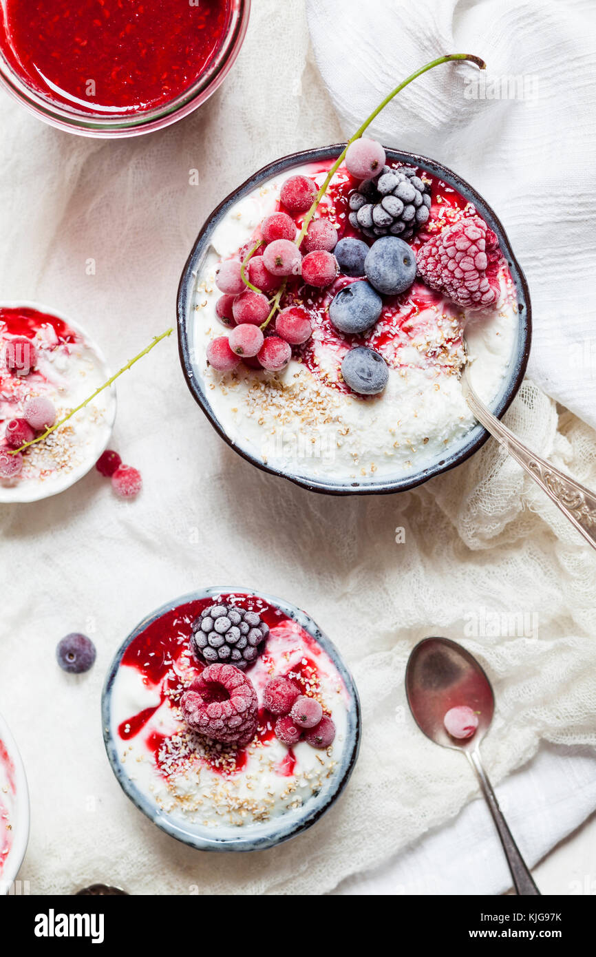 Bowl of natural yoghurt with raspberry sauce and frozen fruits Stock ...