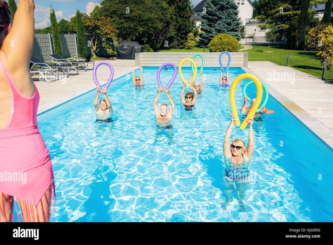 Group of seniors with trainer doing water gymnastics in pool Stock ...