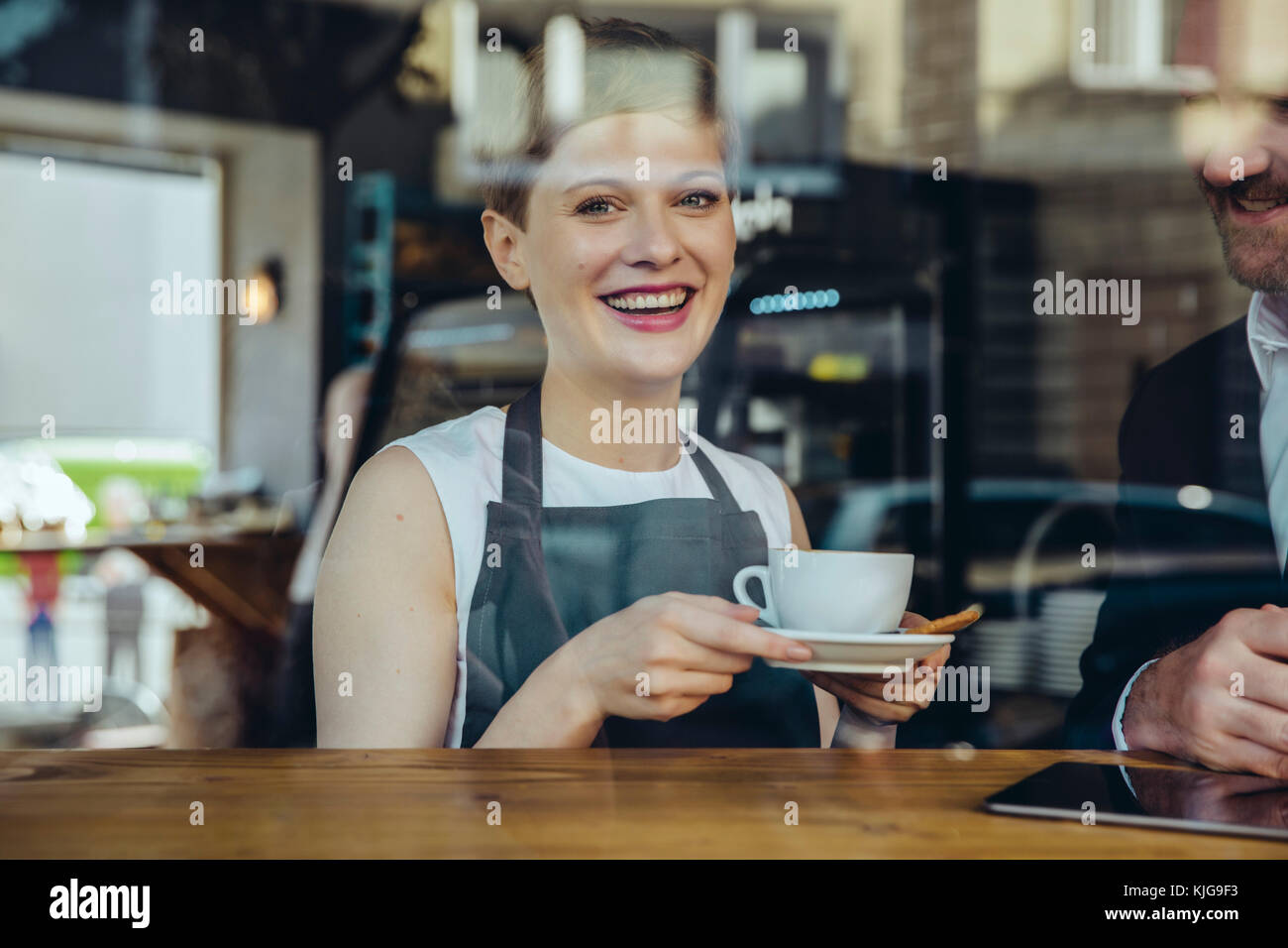 Smiling waitress serving coffee to customer in cafe Stock Photo - Alamy