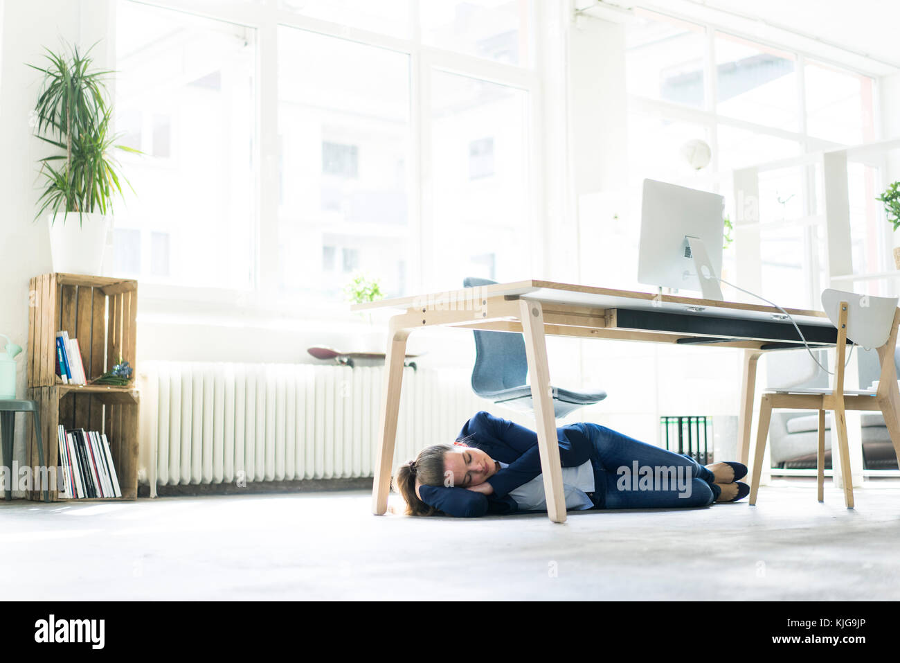 Businesswoman lying under the table in office sleeping Stock Photo - Alamy