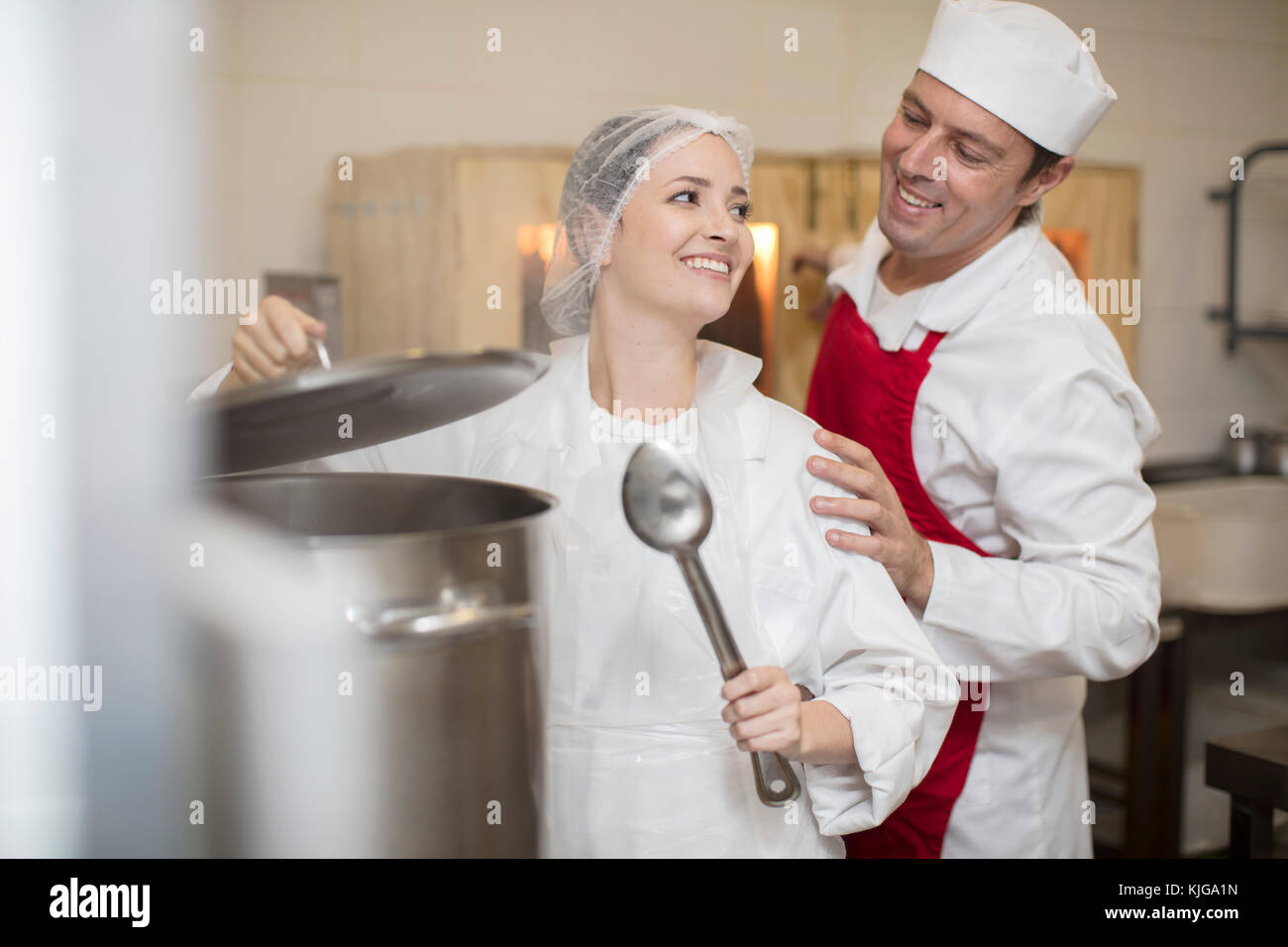 Man and woman cooking in a canteen kitchen Stock Photo - Alamy