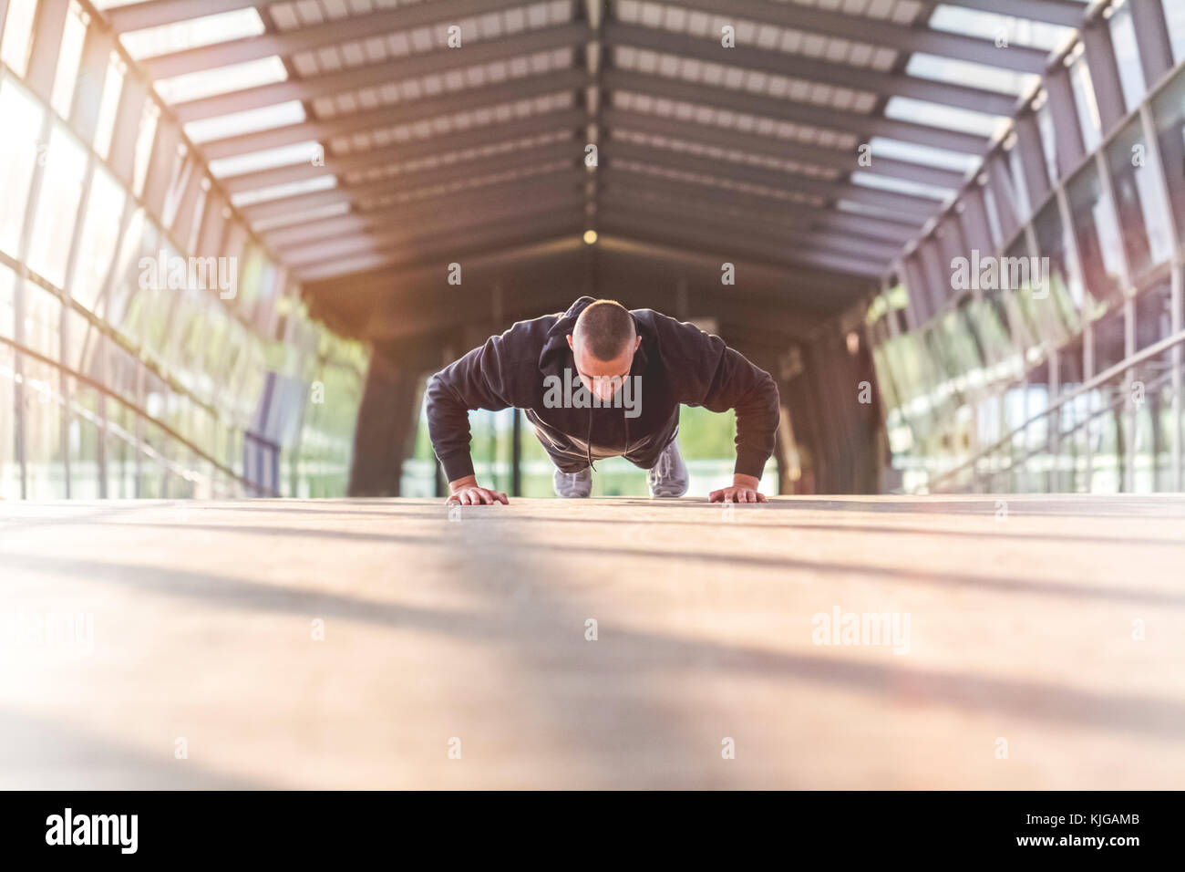 Young man doing push-ups on a bridge Stock Photo - Alamy