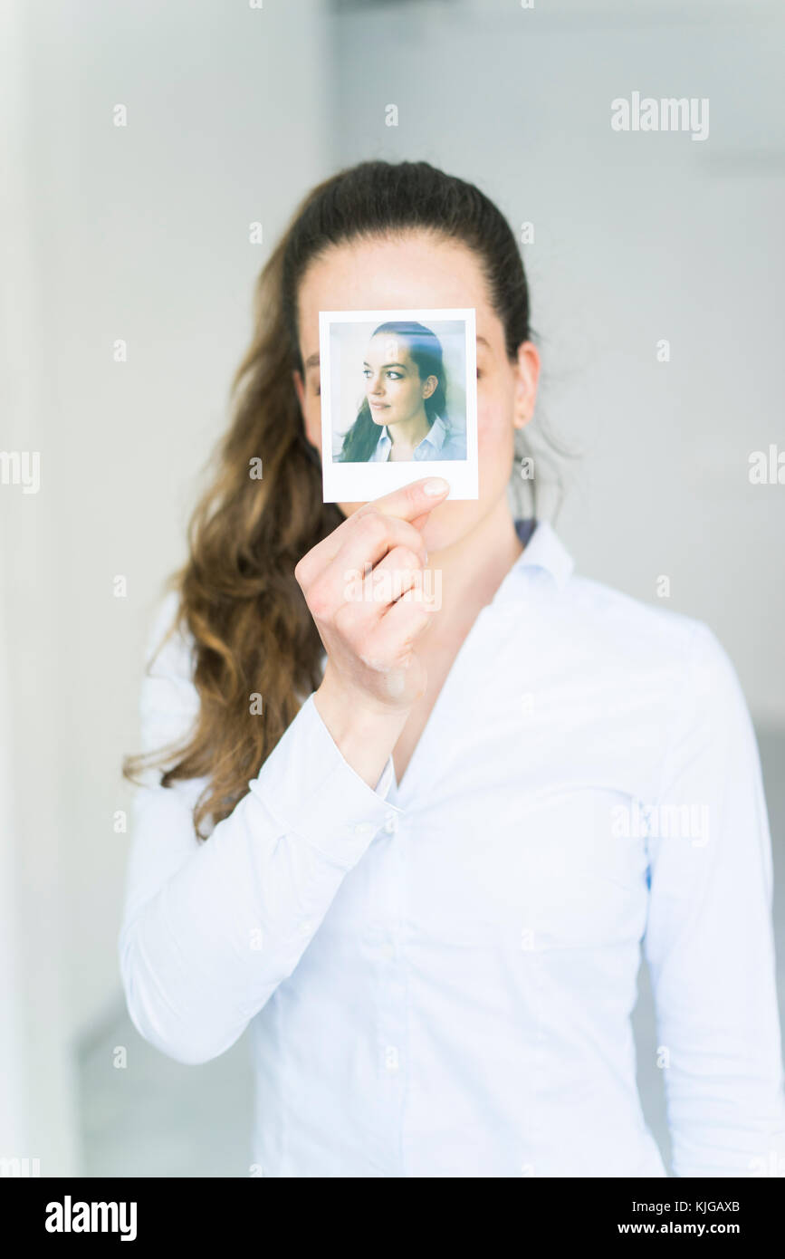 Woman covering her face with instant photo of herself Stock Photo - Alamy