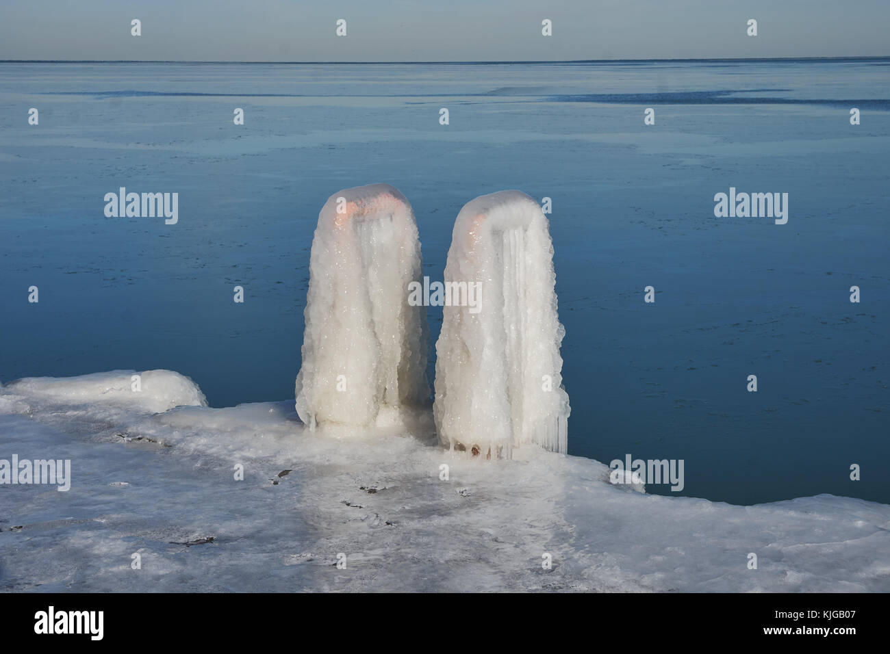 winter view focus on swimming ladder covered in heavy ice with calm ...