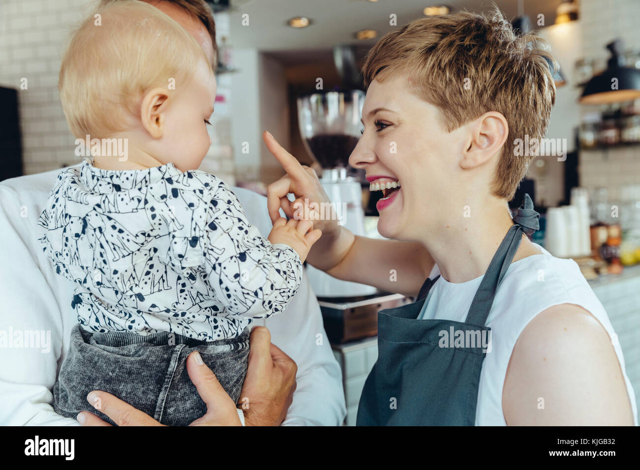 Waitress playing with baby of customer in cafe Stock Photo - Alamy