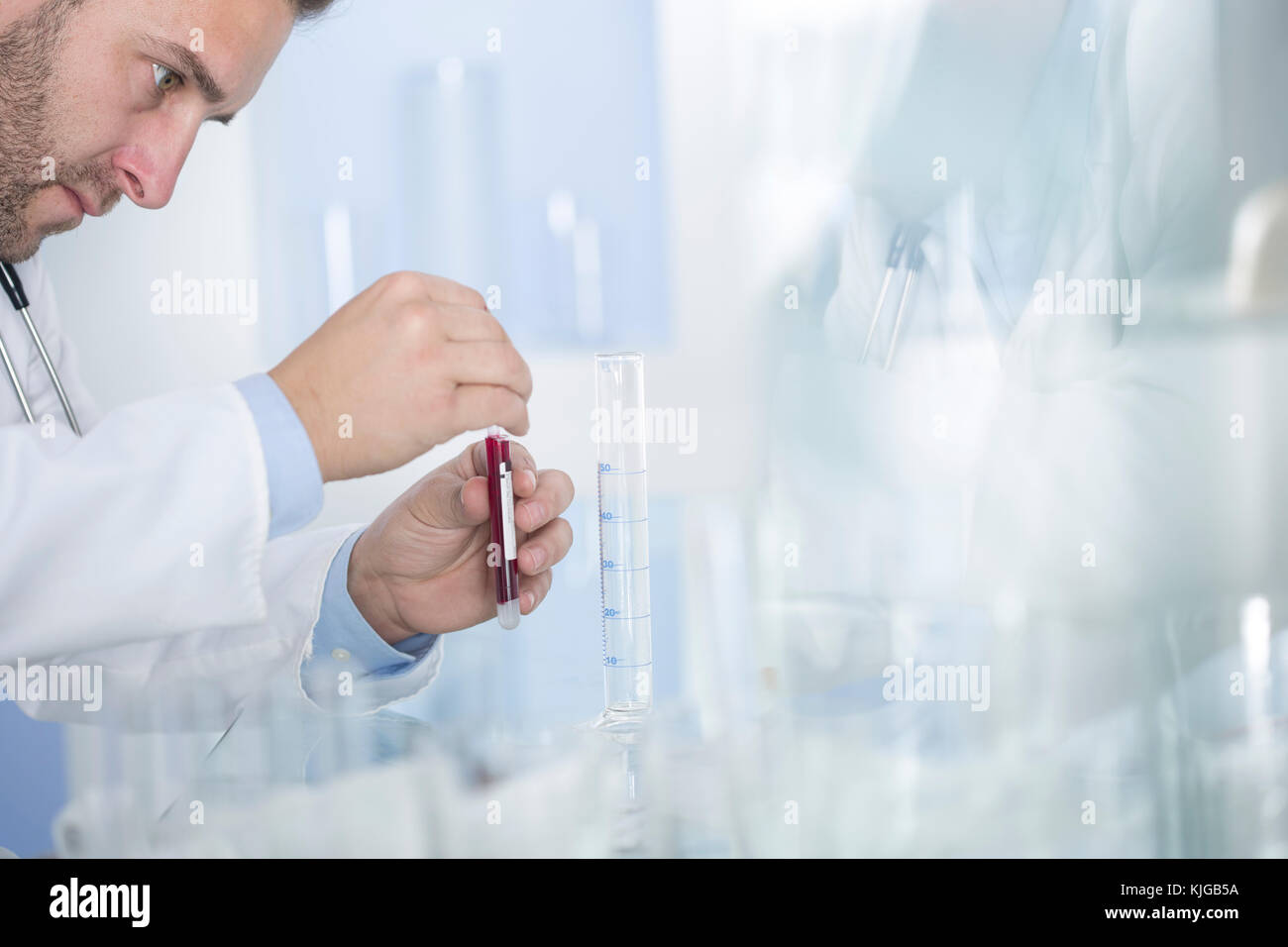 Man examining test tube with liquid in laboratory Stock Photo - Alamy