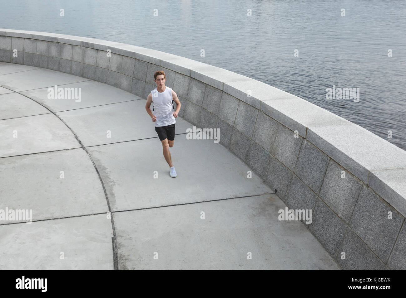 Young man running at the riverbank Stock Photo - Alamy