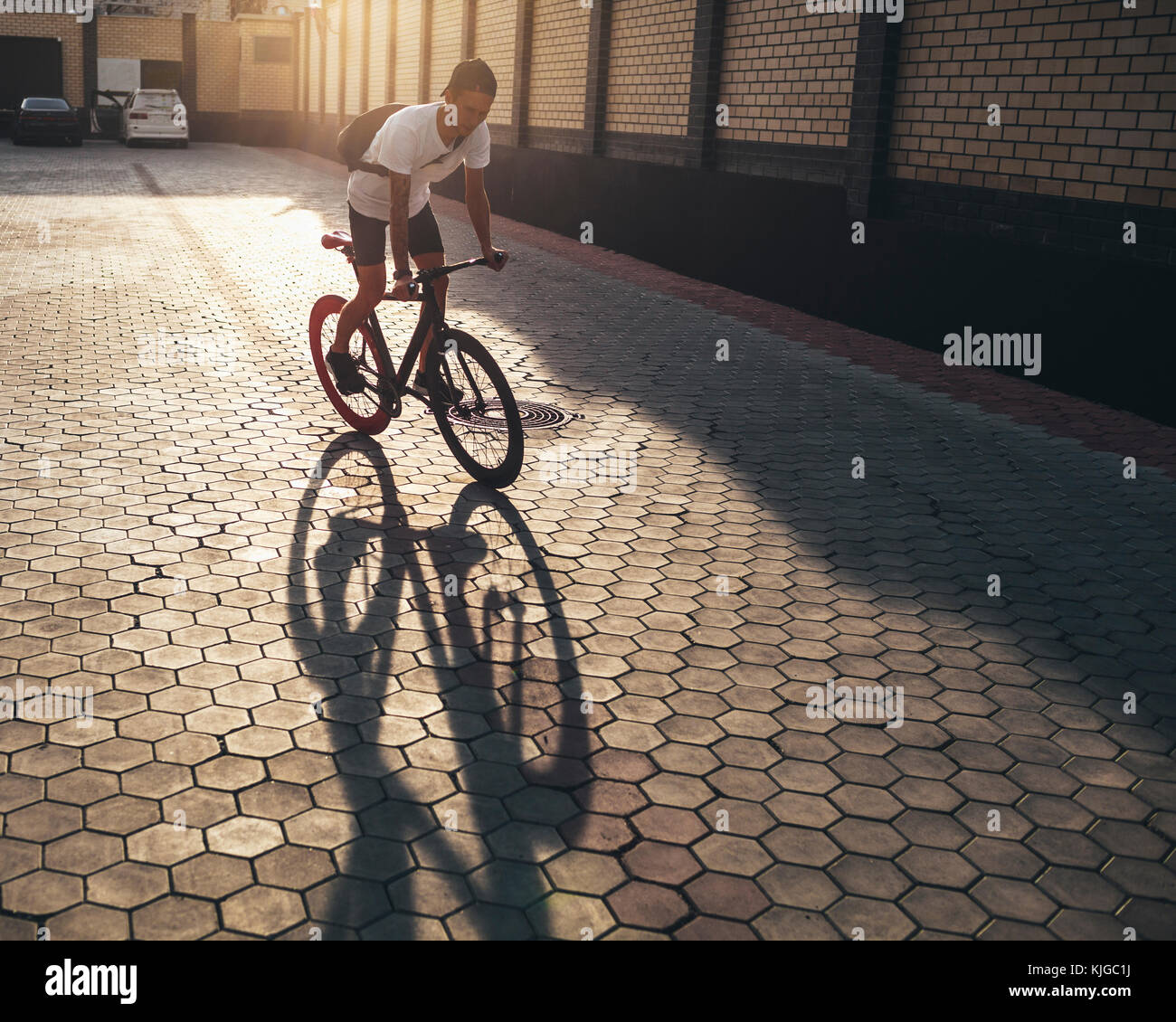 Young man riding fixie bike on backyard at sunset Stock Photo - Alamy