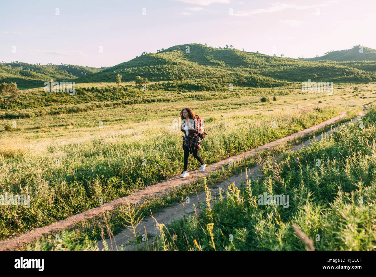 Teenage girl with backpack hiking in nature Stock Photo - Alamy