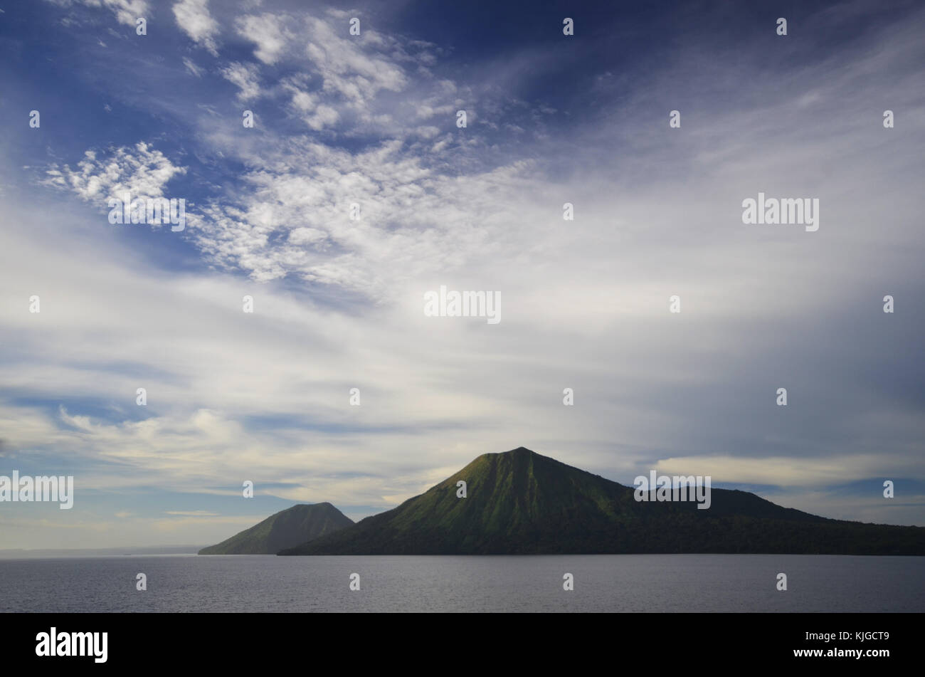 Landscape of volcanoes with cloud formations in sky taken Papua New ...