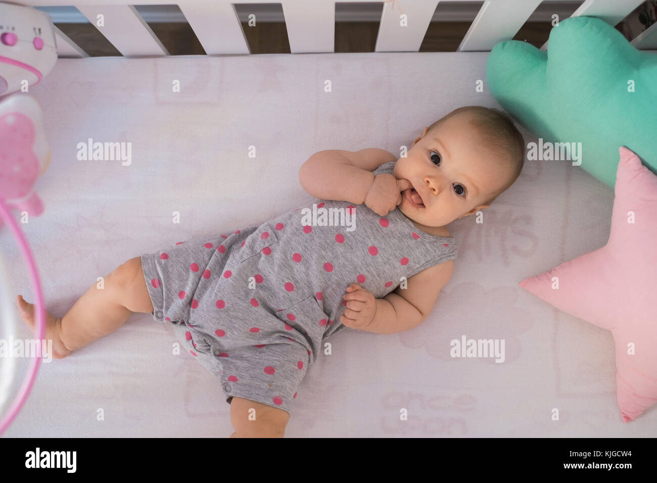 Cute baby girl lying in crib Stock Photo - Alamy