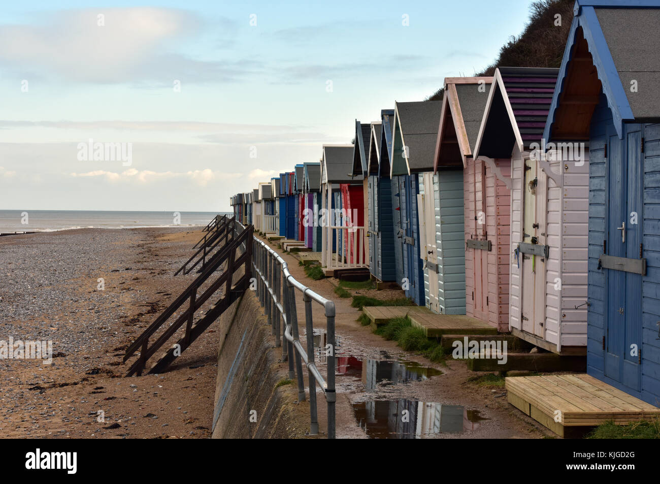 A row od colourful traditional seaside coastal beach huts on the beach ...