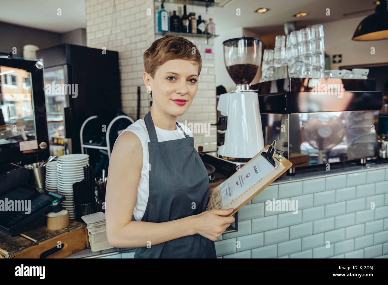 Portrait of waitress holding menu in a cafe Stock Photo - Alamy