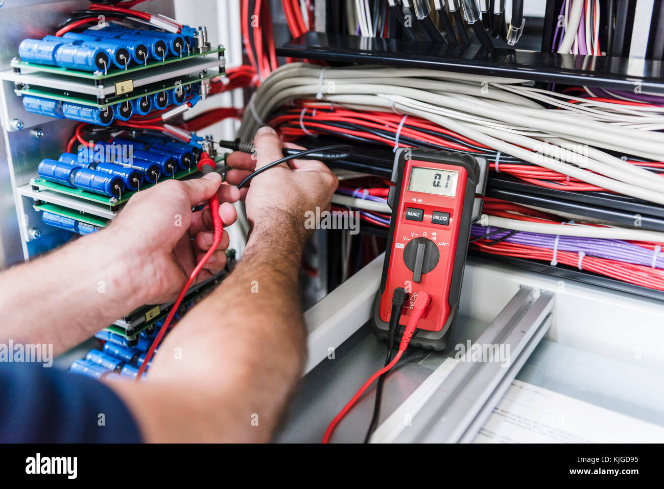 Close-up of man using voltmeter in factory Stock Photo - Alamy