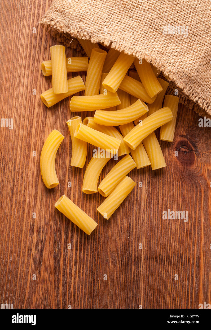 Portion of uncooked Pasta on rustic wooden background Stock Photo - Alamy