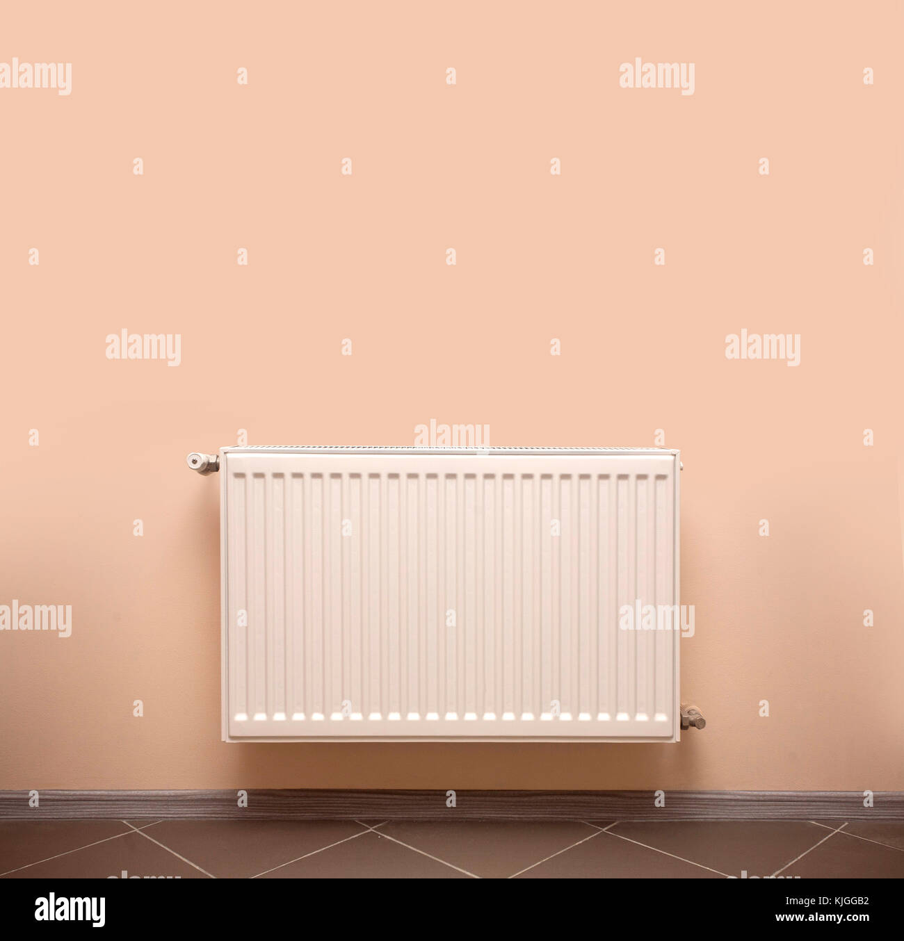 radiator on a light beige wall Stock Photo - Alamy