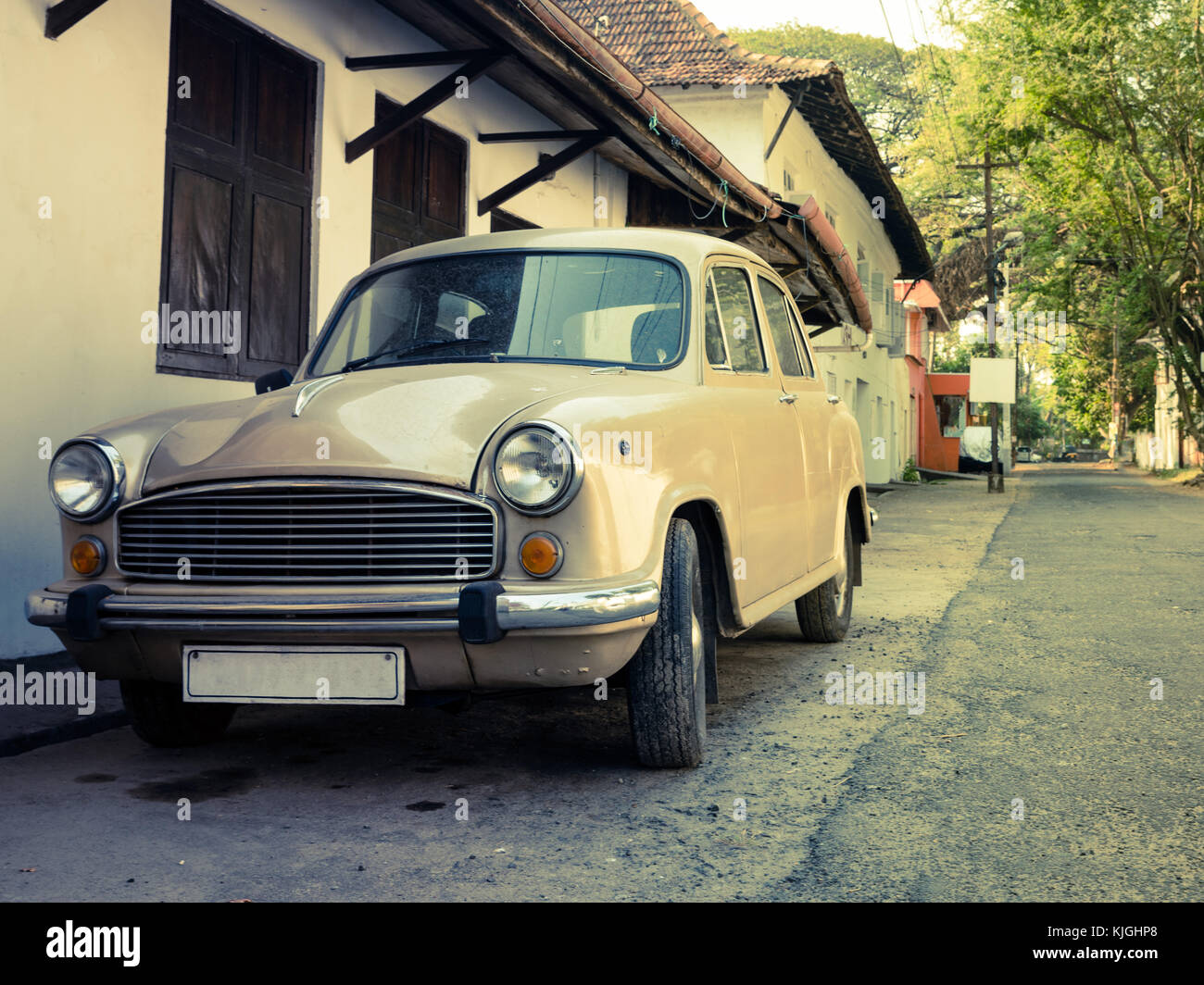 Vintage retro car, beige/sand color, parked in a empty street in front ...