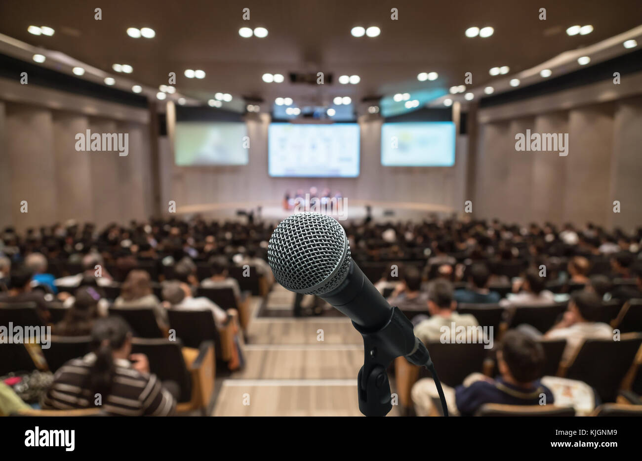 Microphone over the Abstract blurred photo of conference hall or ...