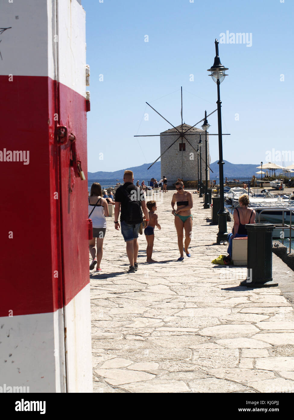 Sunbathers on causeway to lighthouse at Garitsa Bay, Corfu Town ...