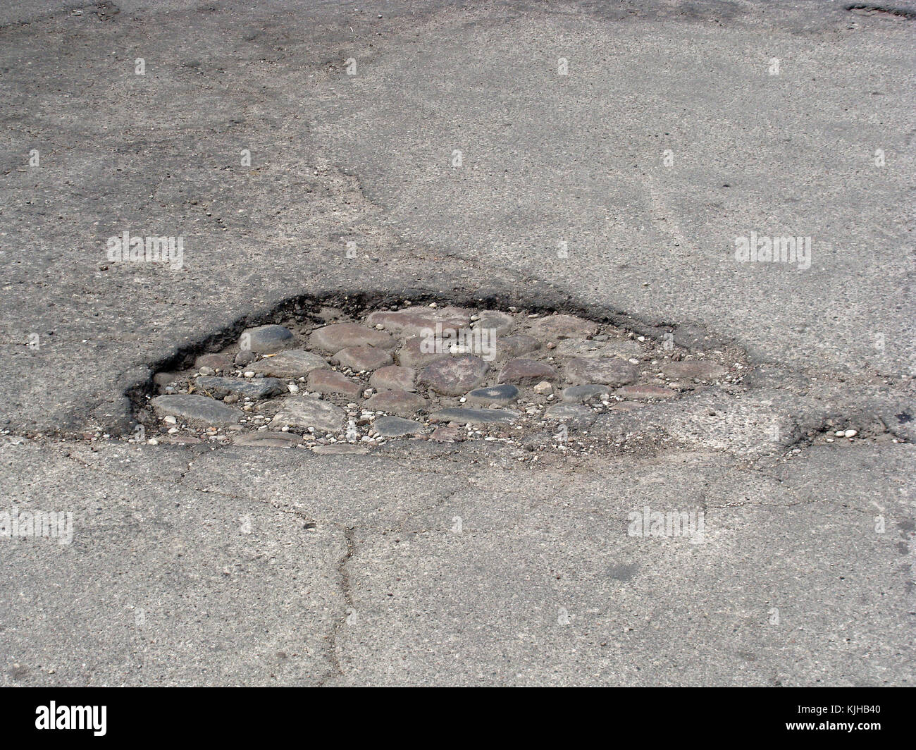 Street with damaged asphalt with big holes in surface Stock Photo - Alamy