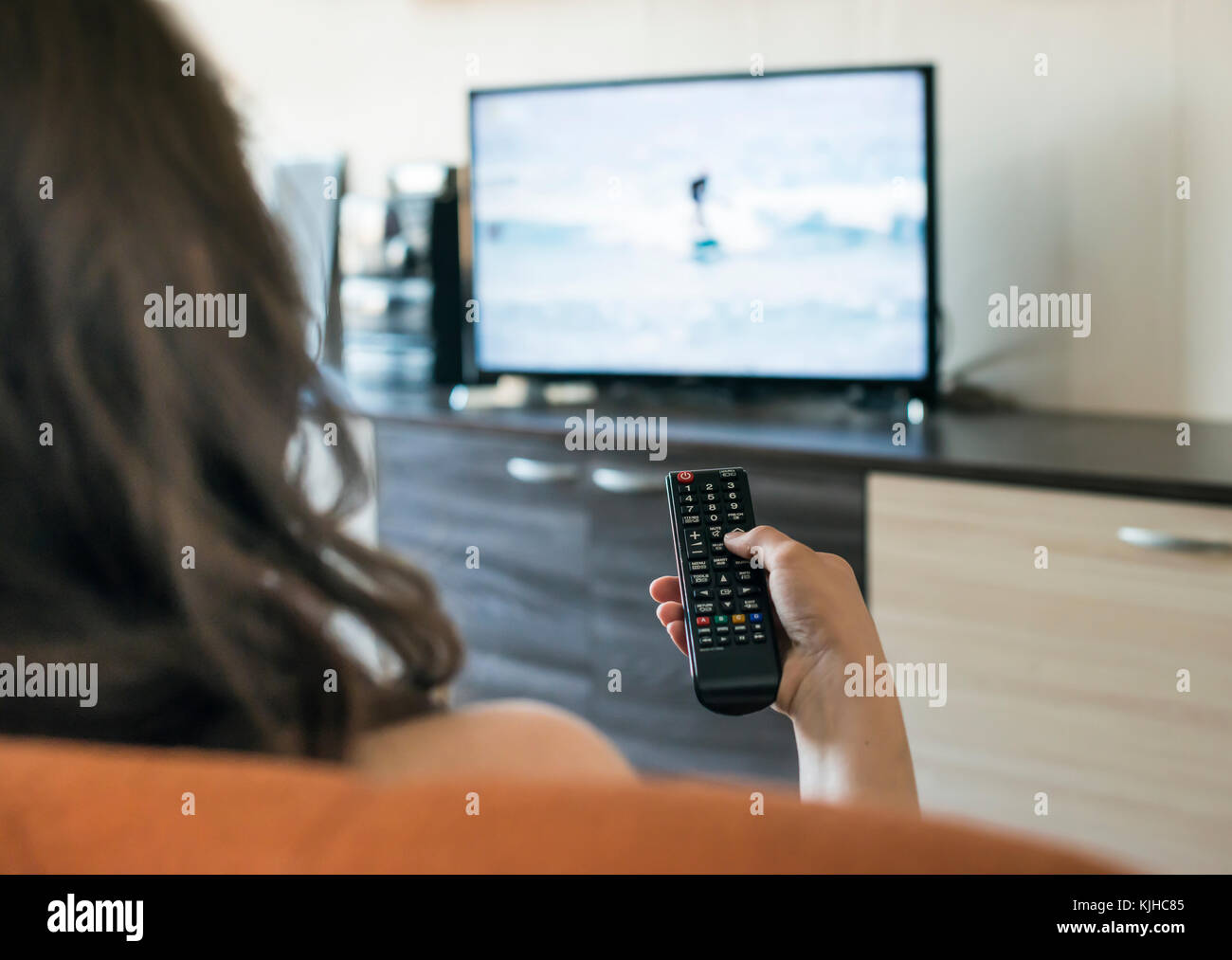 Woman hold TV remote control. TV on the background Stock Photo - Alamy