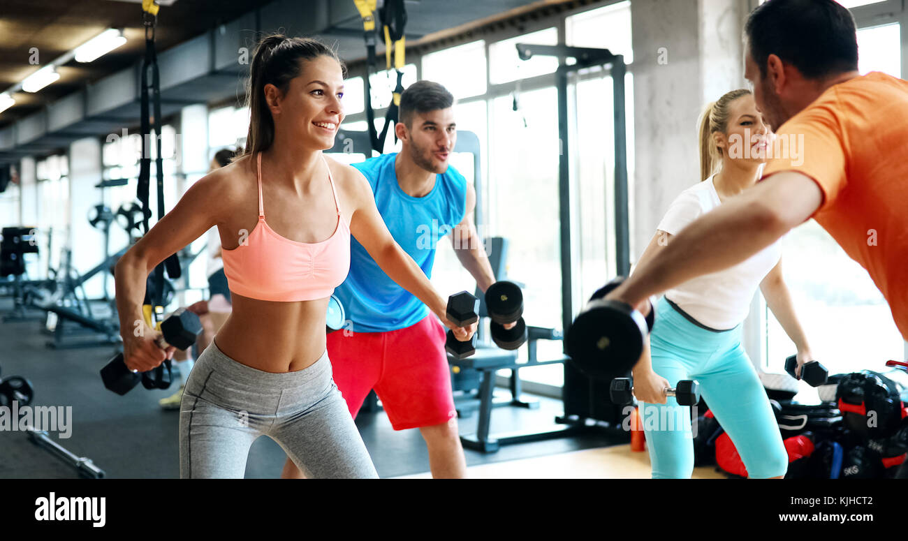 Beautiful woman doing exercises in gym with personal trainer Stock ...