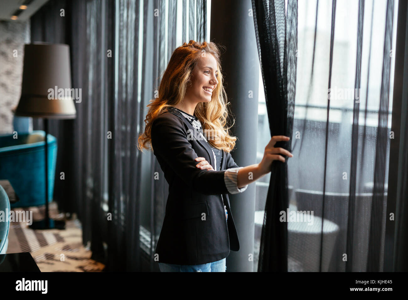 Glamorous woman staring through window Stock Photo - Alamy