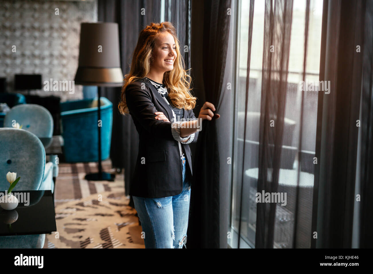 Glamorous woman staring through window Stock Photo - Alamy
