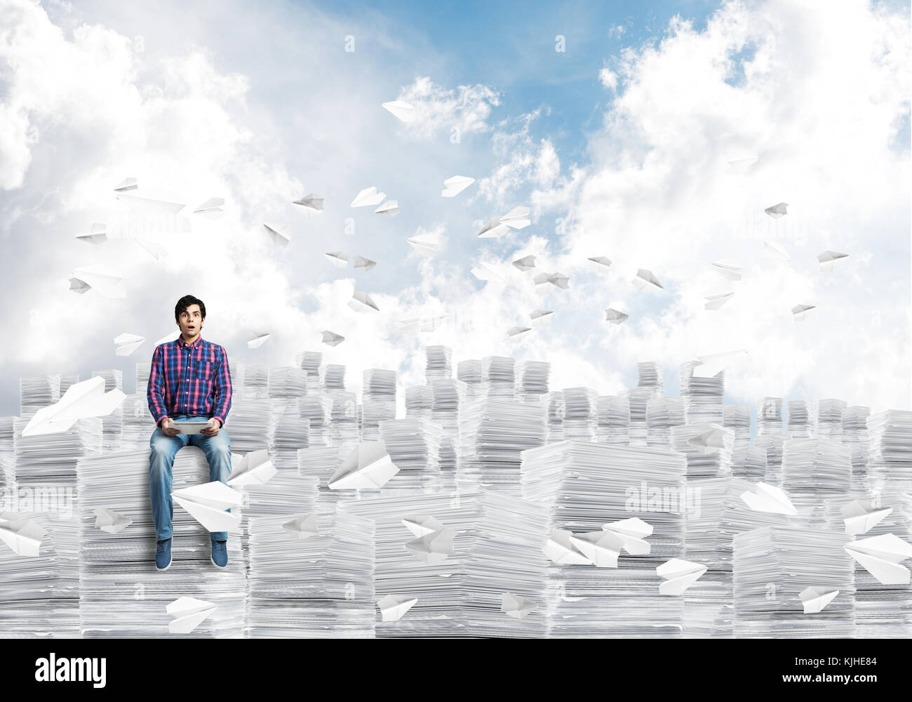 Attractive man sitting on pile of paper documents Stock Photo - Alamy