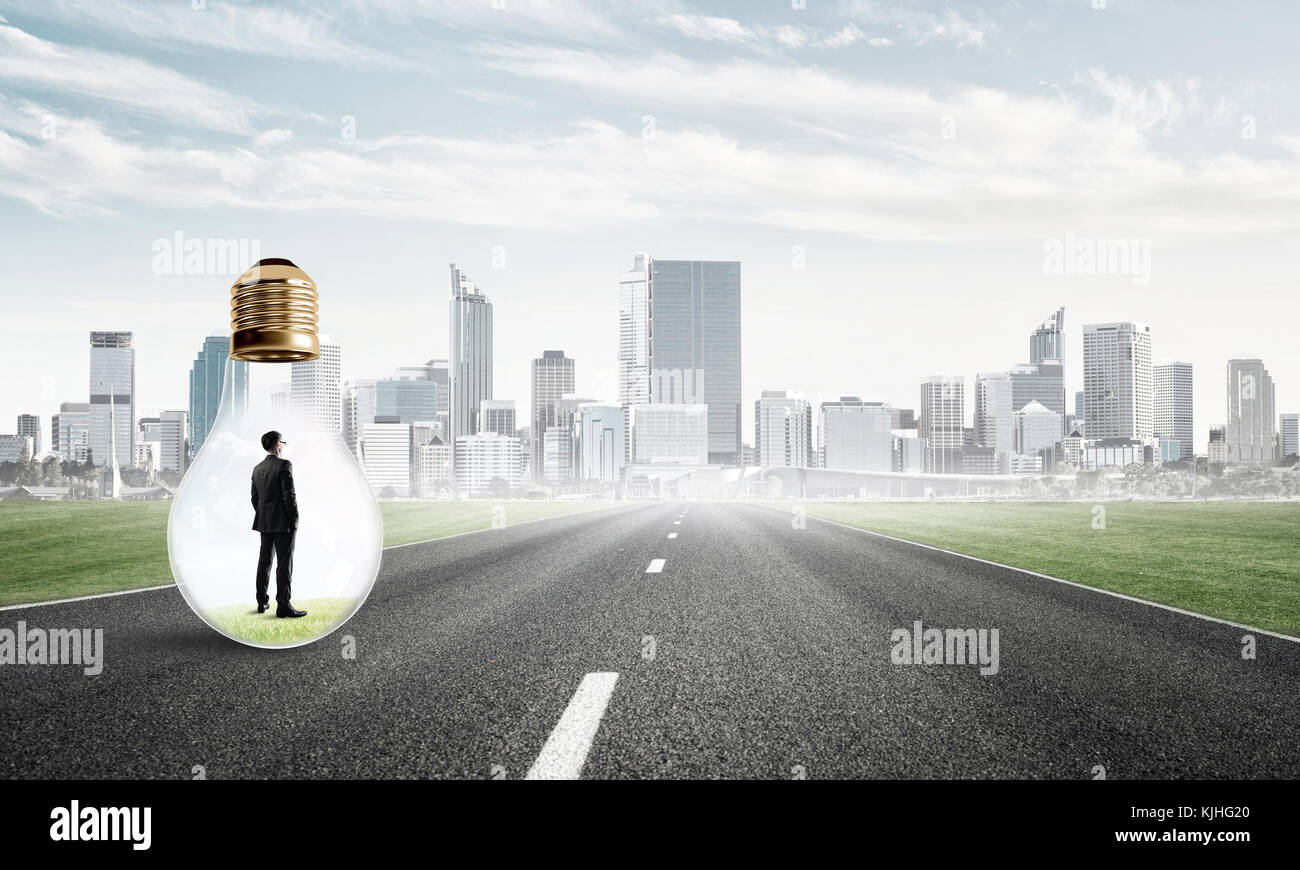 Businessman inside light bulb Stock Photo - Alamy