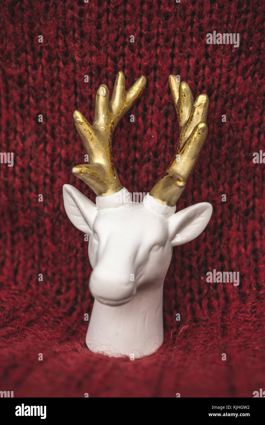 Statue of deer on red wool sweater Stock Photo - Alamy