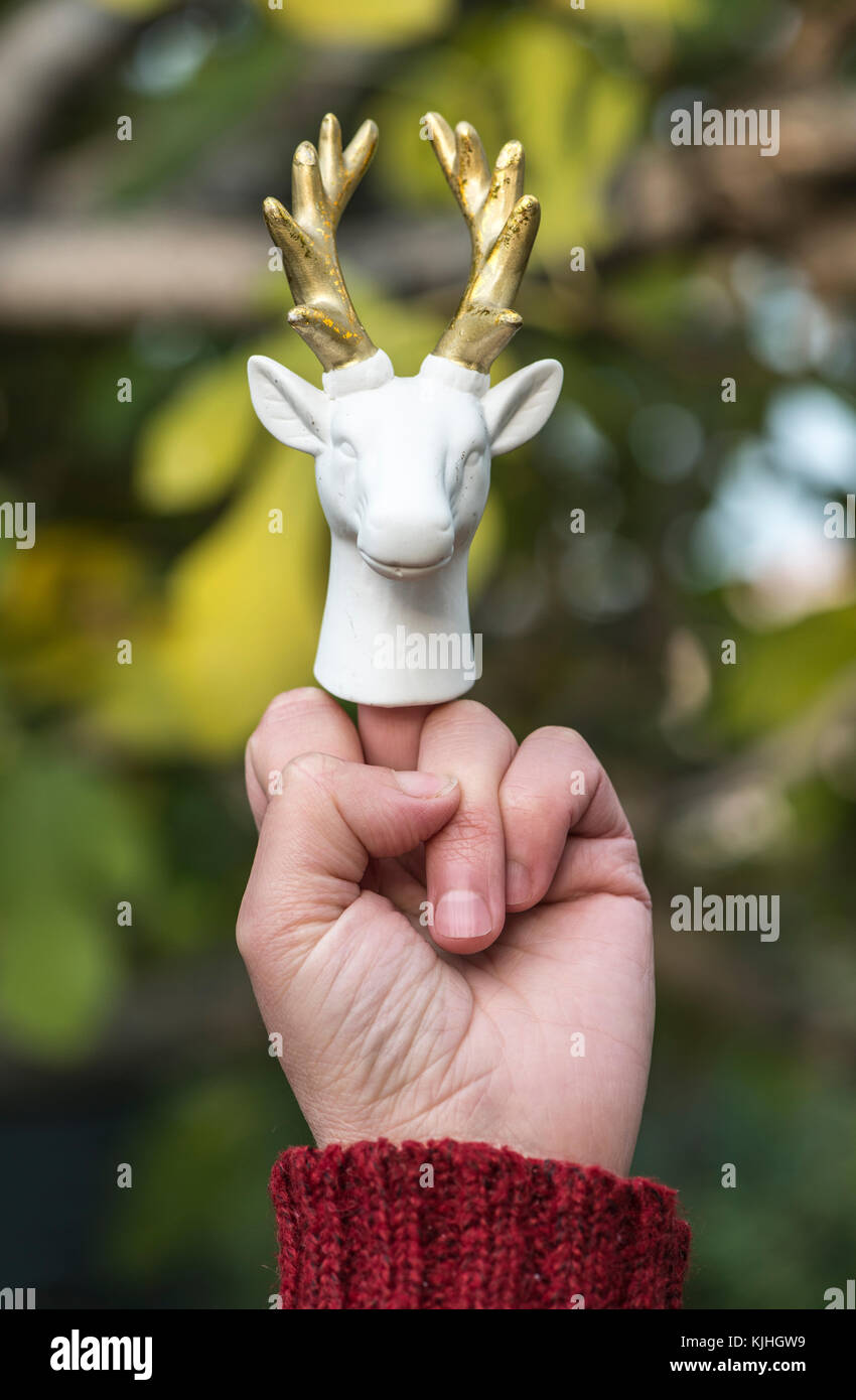 Statue of white deer on middle finger. Close up Stock Photo - Alamy