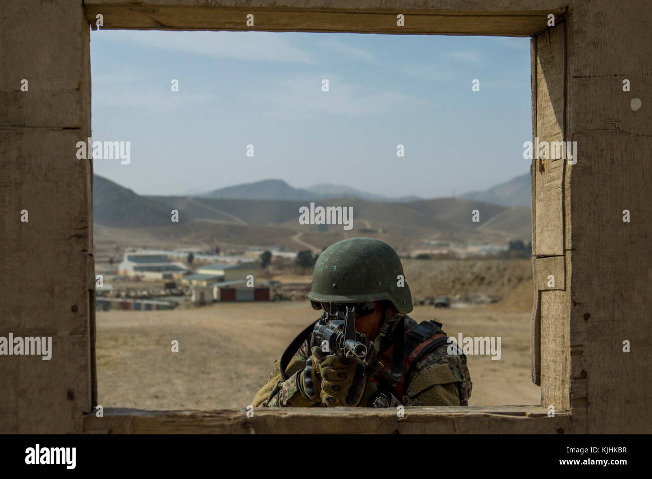 An Afghan Commando scans his sector while moving to assault a compound ...