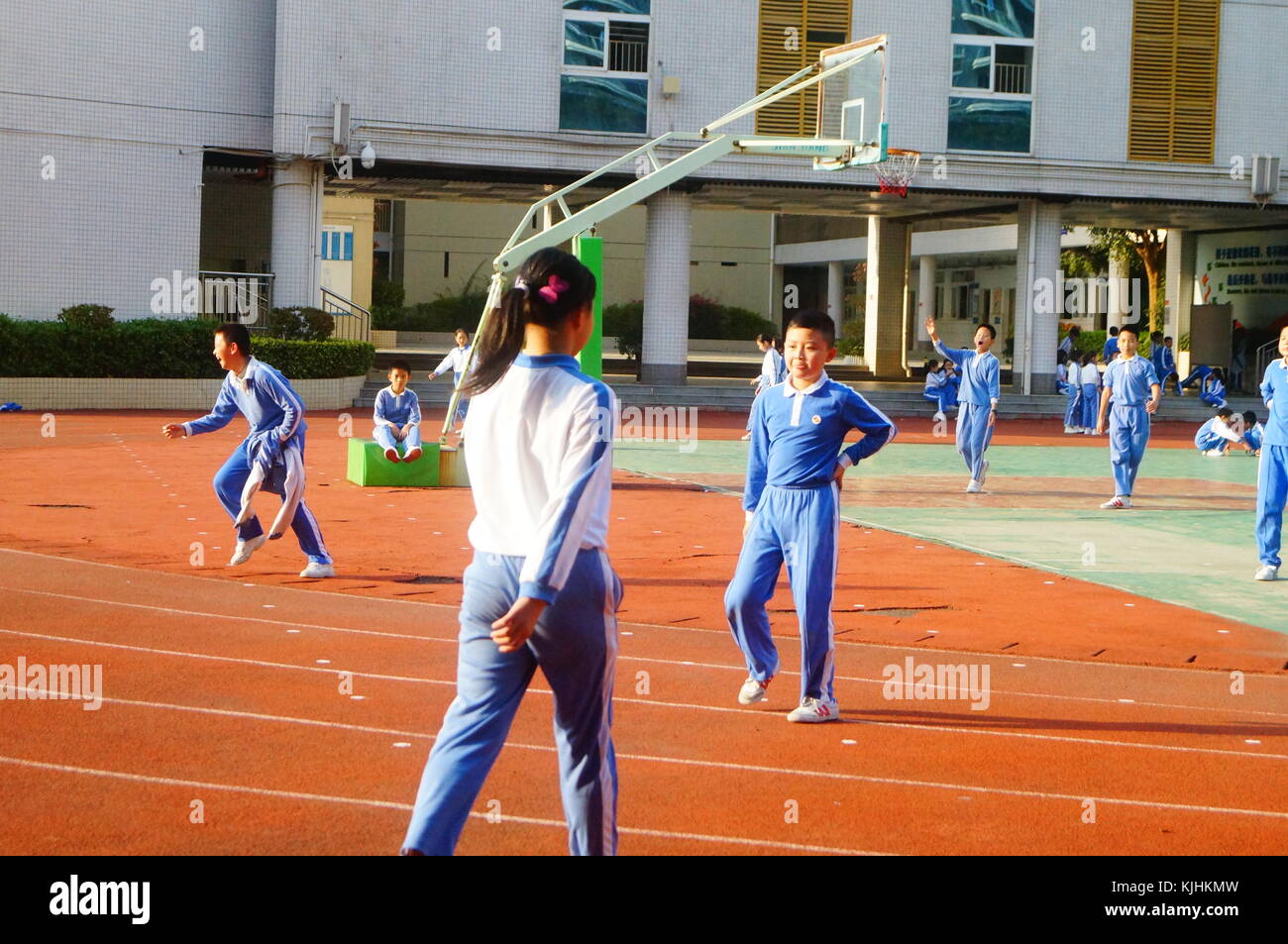 The pupils are having PE lessons on the school playground, and the ...