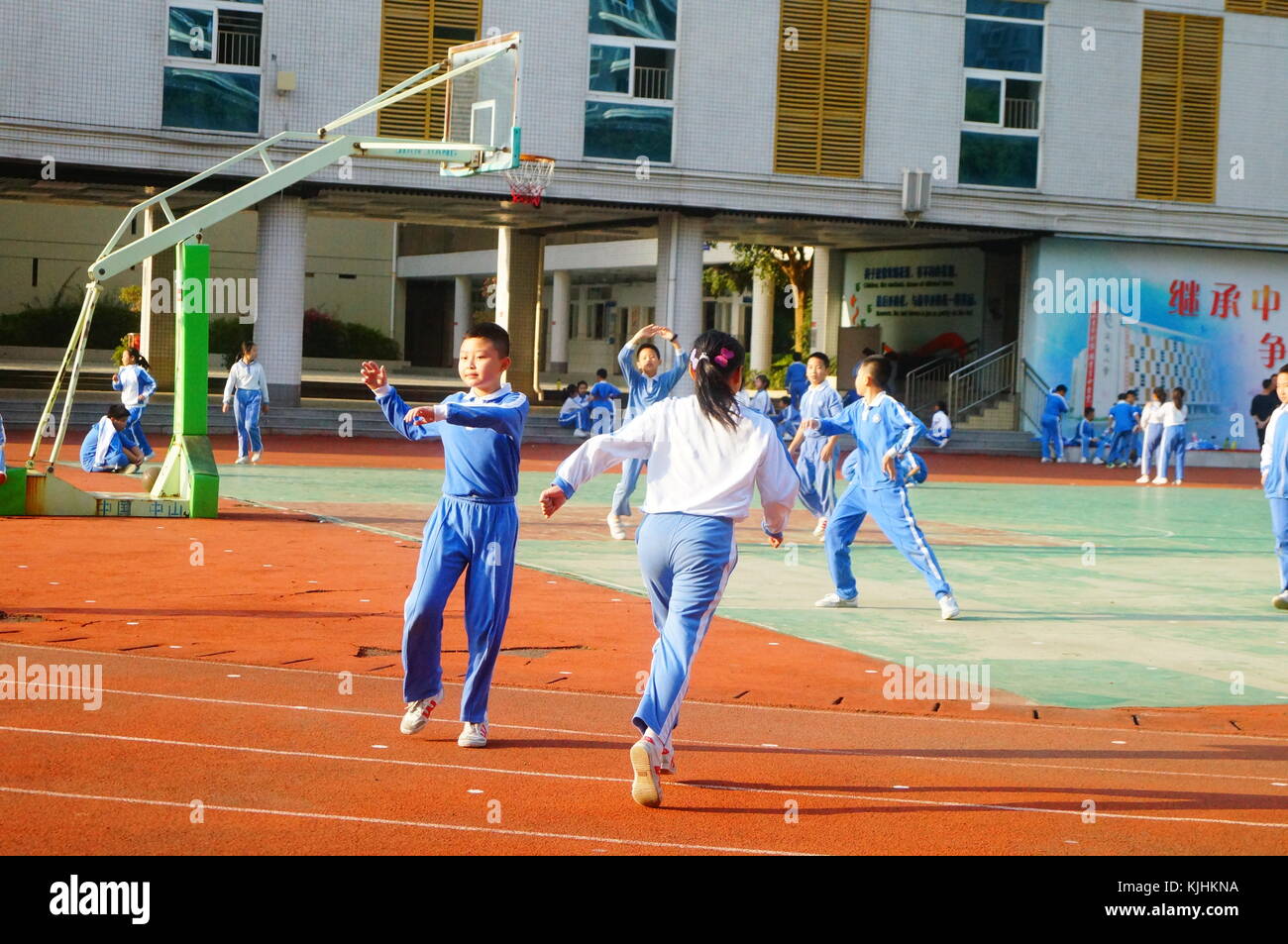 The pupils are having PE lessons on the school playground, and the ...