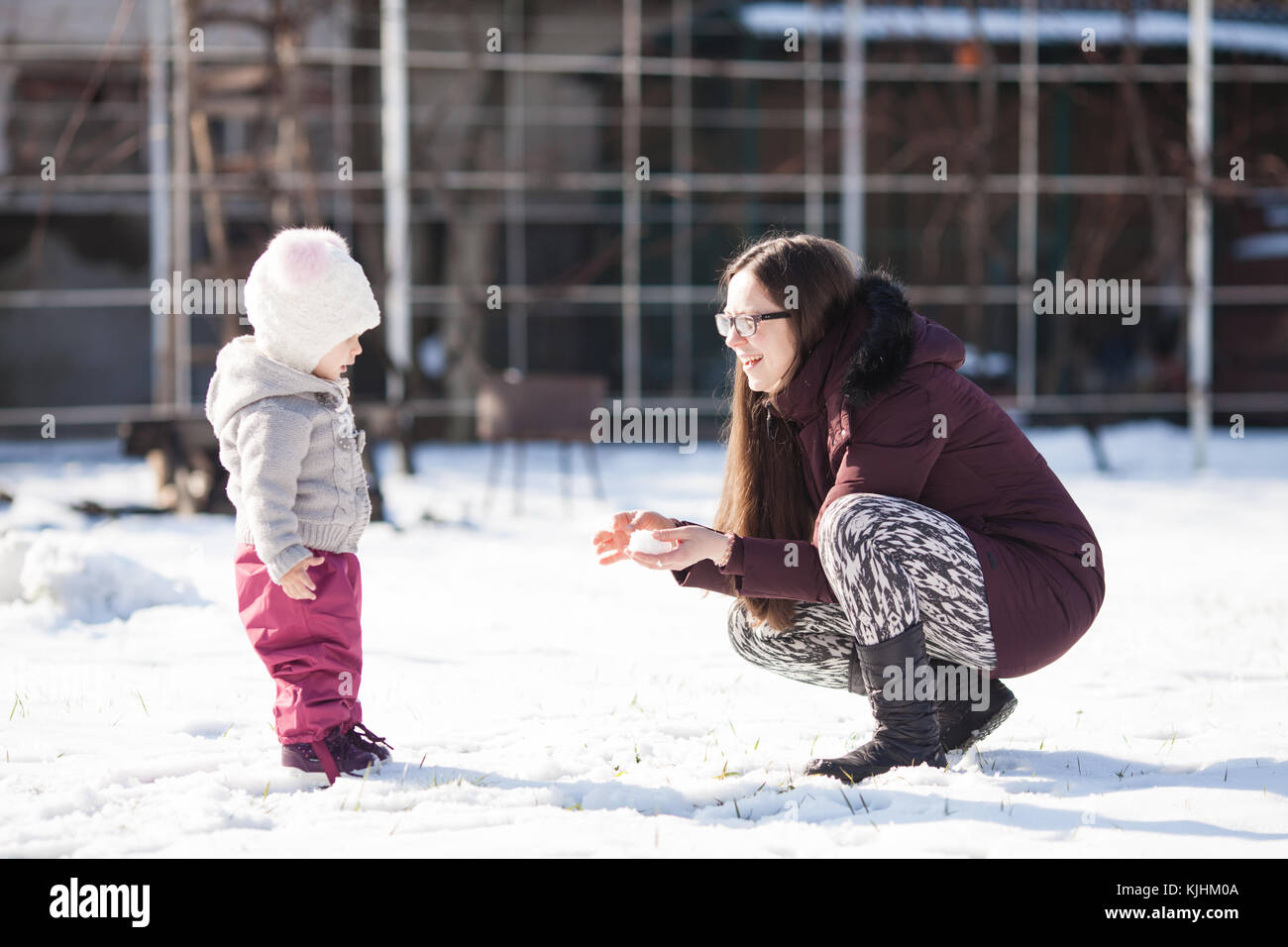 Mom shows the snow to a little girl at the cold sunny winter day Stock ...