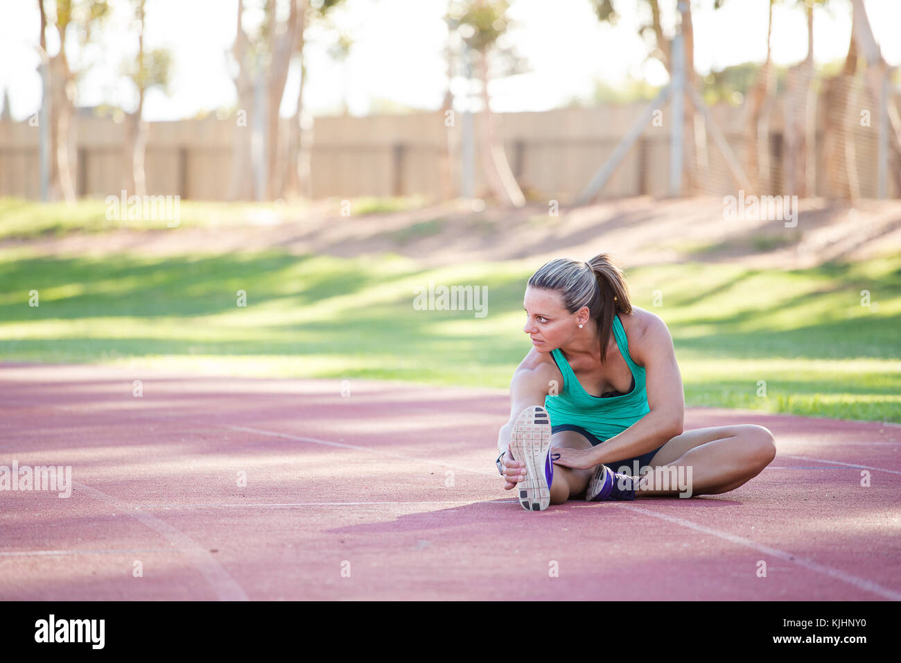 Close up wide angle view of a female sprinter athlete getting ready to ...
